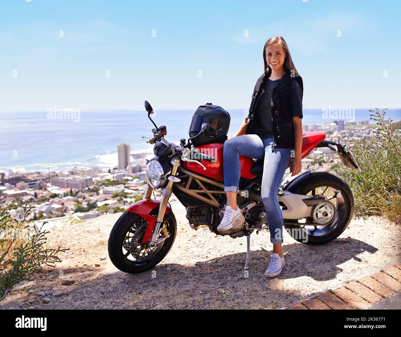 Ah, the life of a biker...A beautiful young woman sitting on her red ...