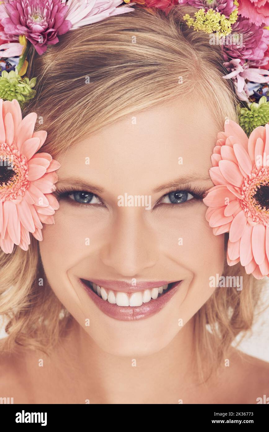 Giving you a toothy spring smile. A young woman with a flower ...