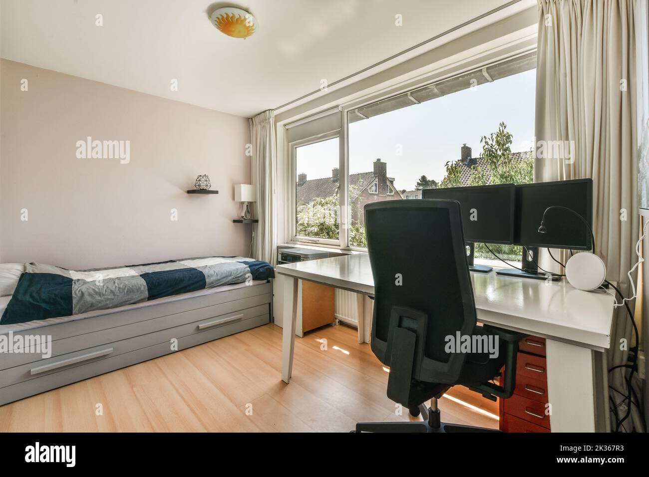 Comfortable chair placed near desk with computer monitors dim light ...