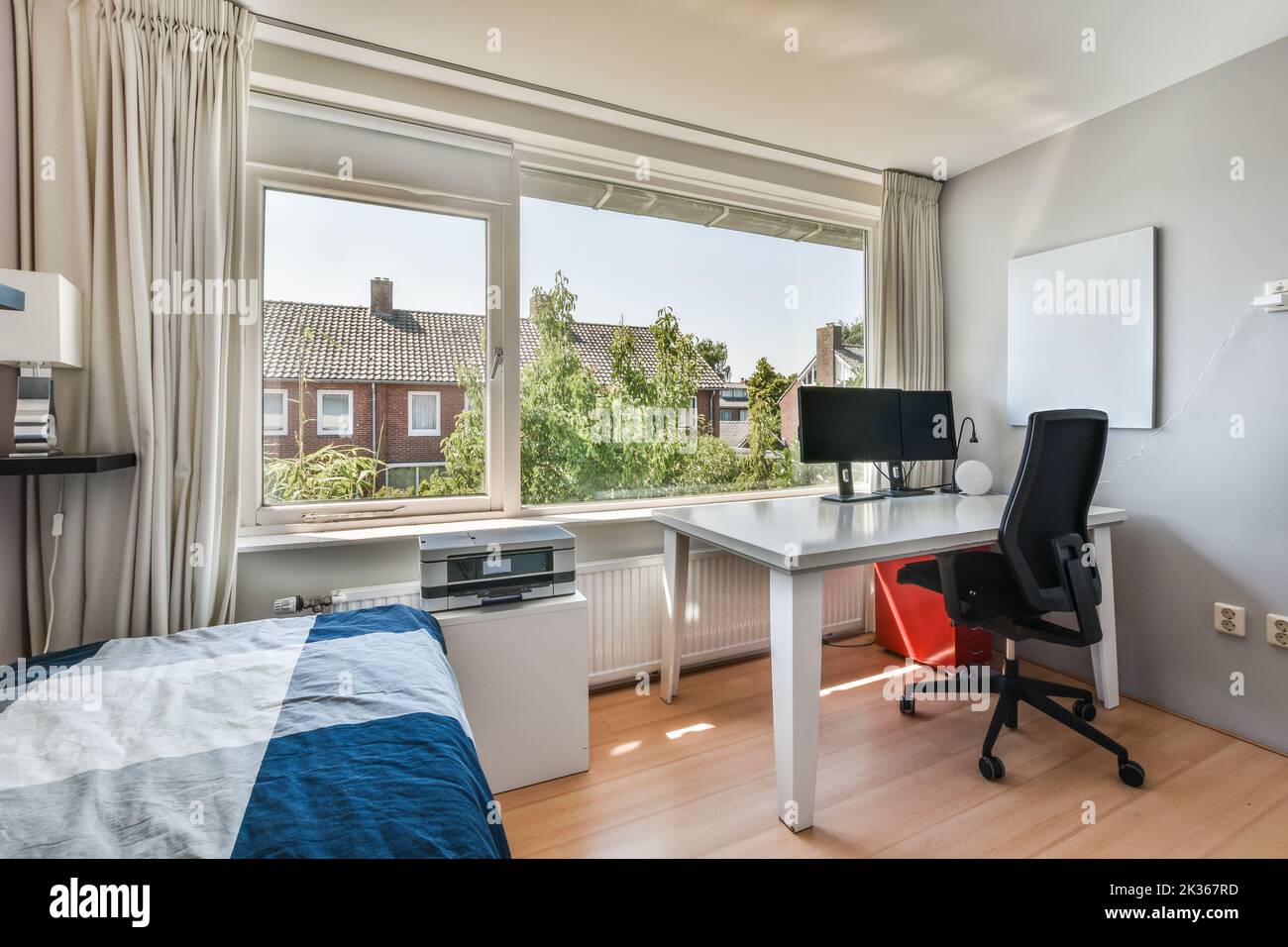 Comfortable chair placed near desk with computer monitors dim light ...