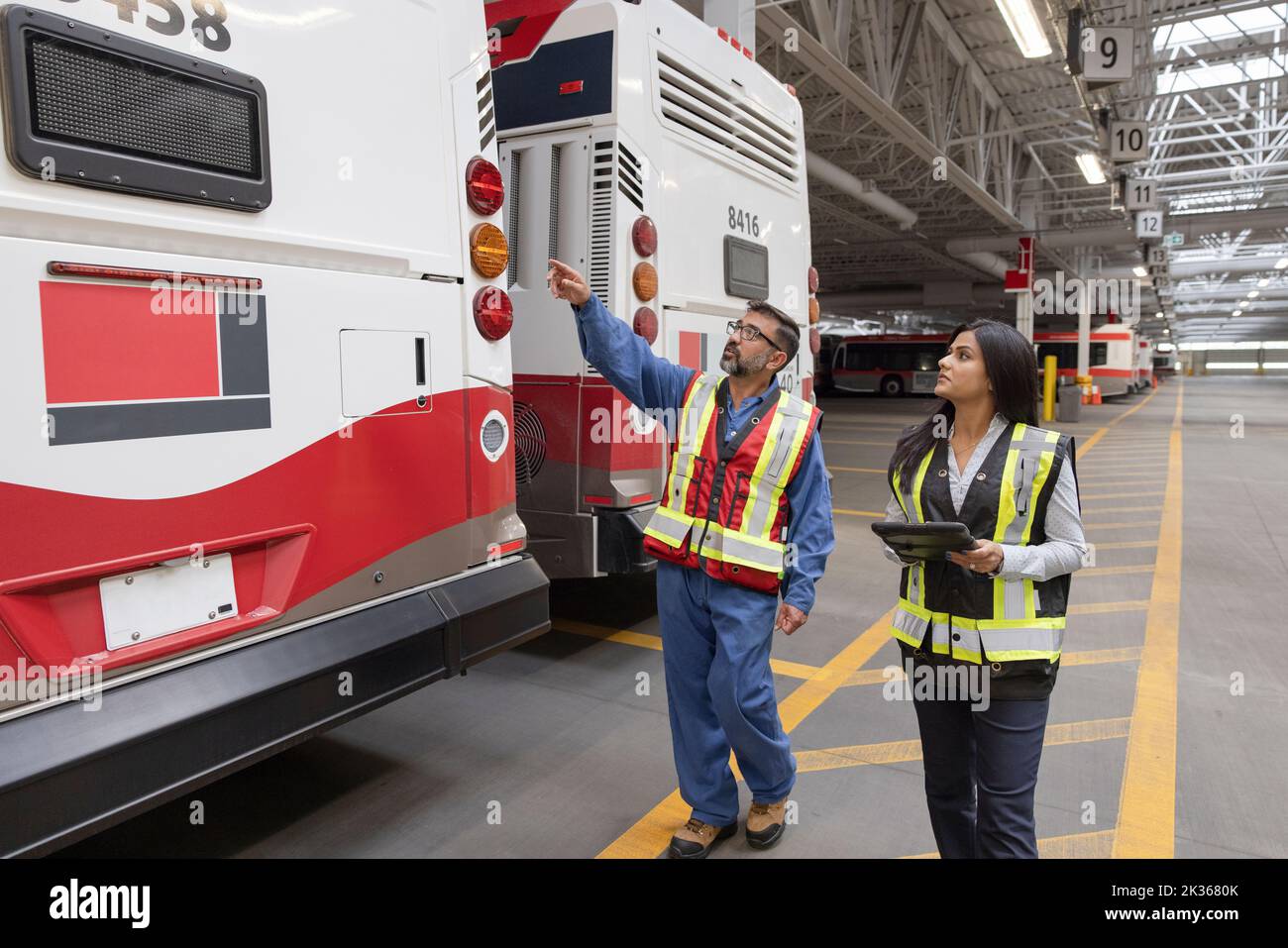 Workers inspecting buses in transit garage Stock Photo - Alamy