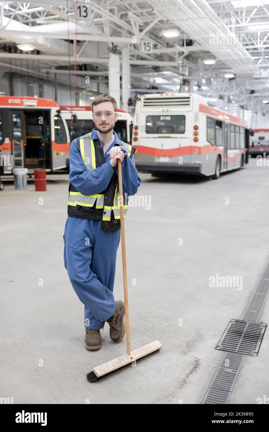 Portrait confident male worker with broom in maintenance facility Stock ...