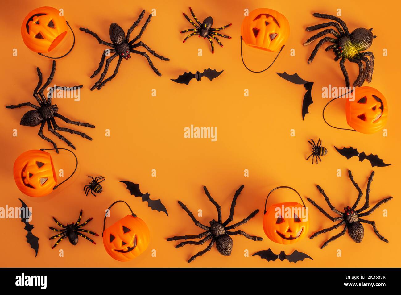 Halloween decorations, pumpkins, bats, spiders on orange background ...