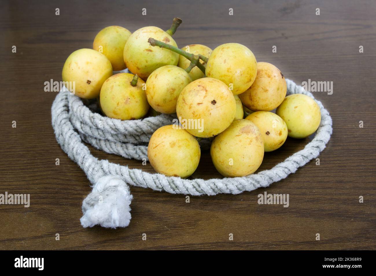 Baccaurea motleyana also known as lotkon isolate on wooden background ...
