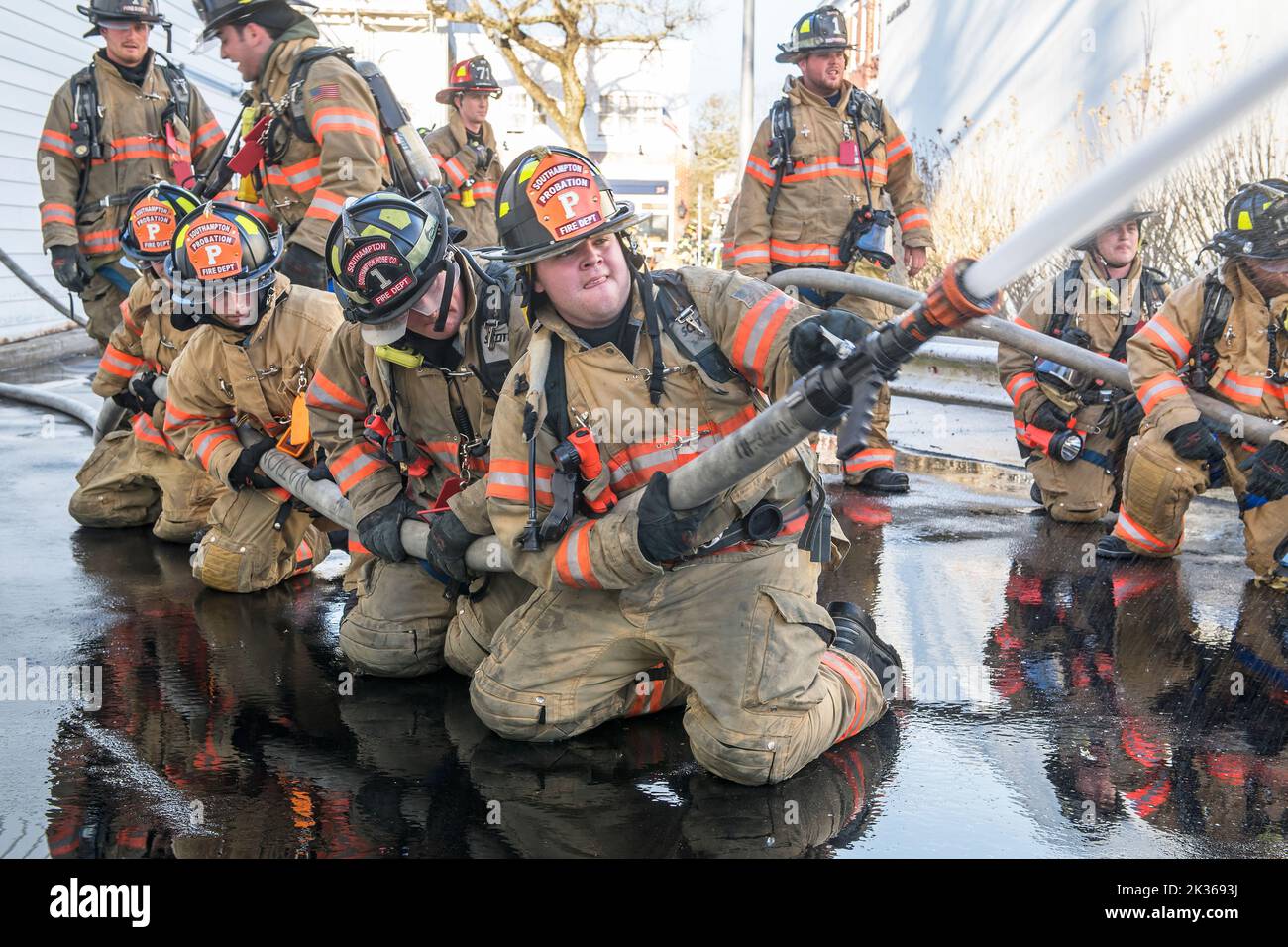 Probationary firefighters get practice handling the hose as the ...