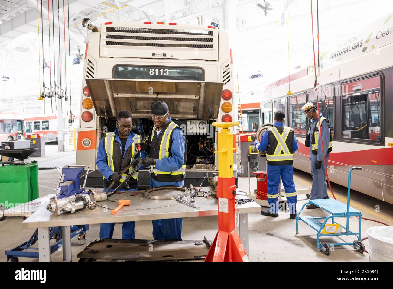 Male mechanics fixing bus part in maintenance facility Stock Photo - Alamy