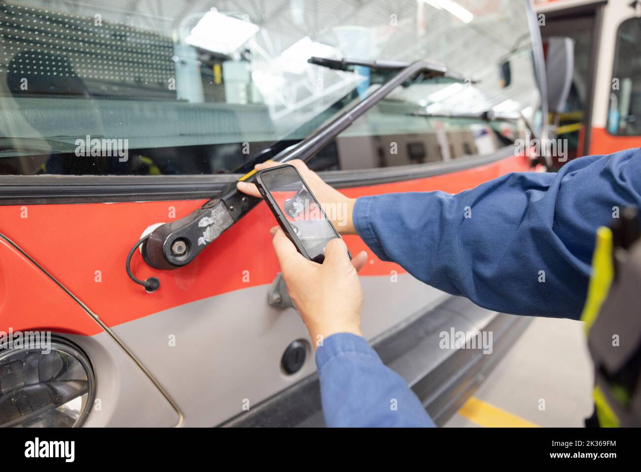 Male engineer photographing bus windshield wiper Stock Photo - Alamy