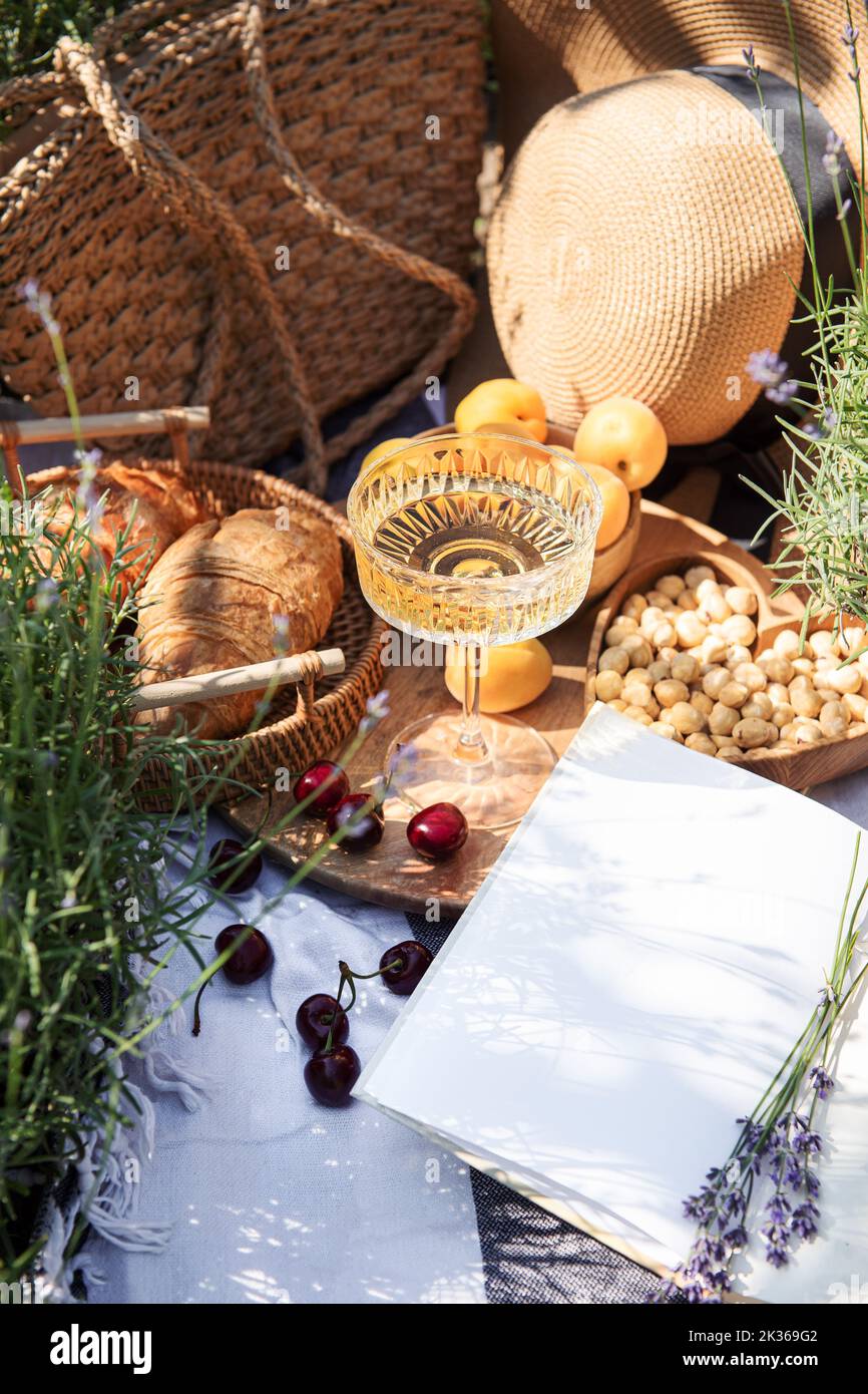 Summer picnic on a lavender field with champagne glasses, croissants ...