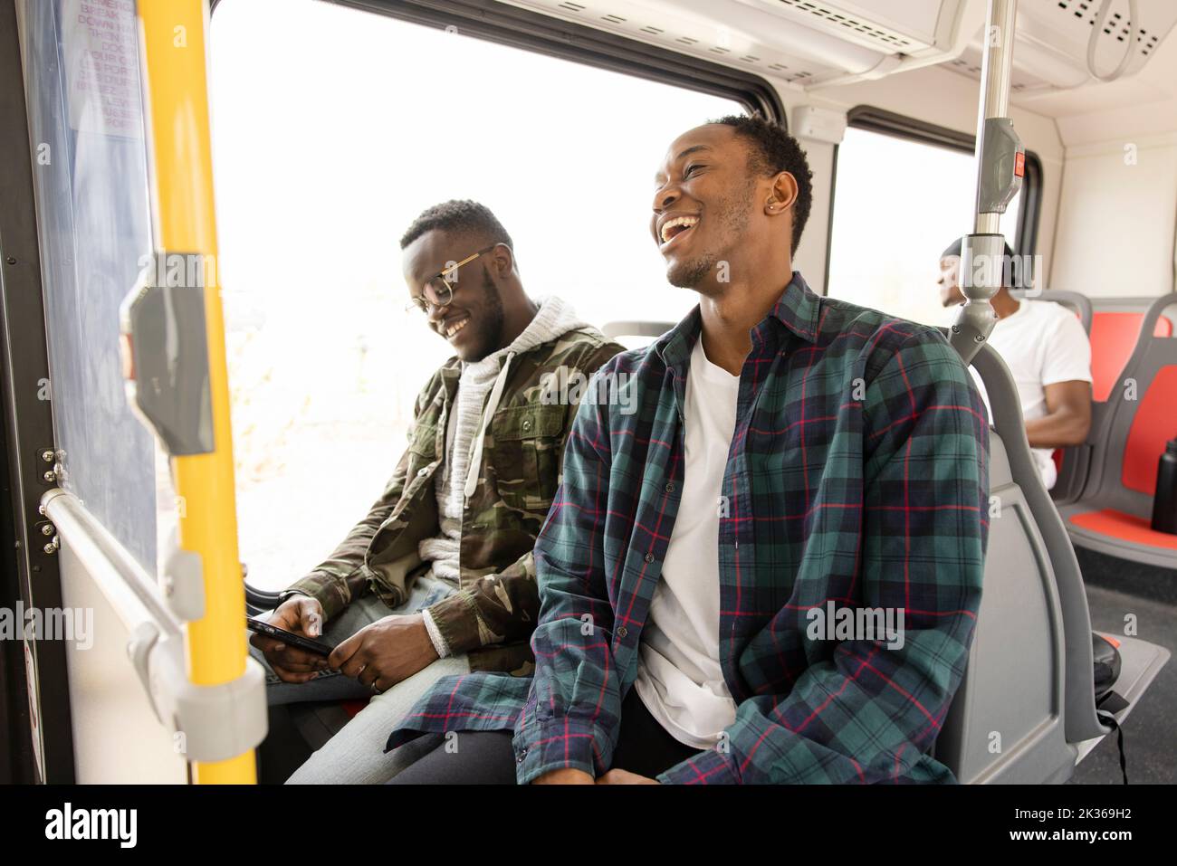 Happy male friends laughing on public transit bus Stock Photo - Alamy