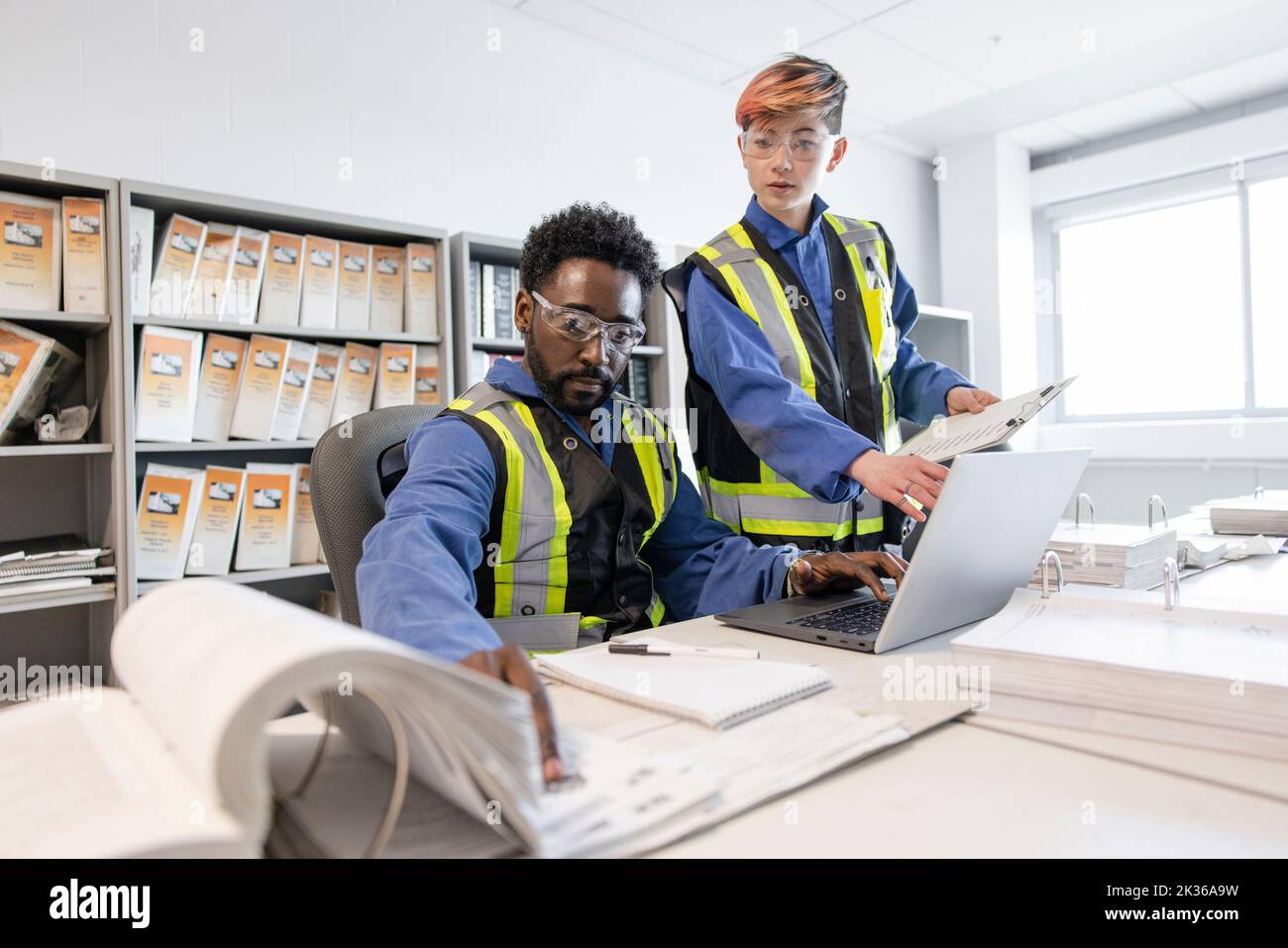 Two men looking at paperwork standing up hi-res stock photography and ...