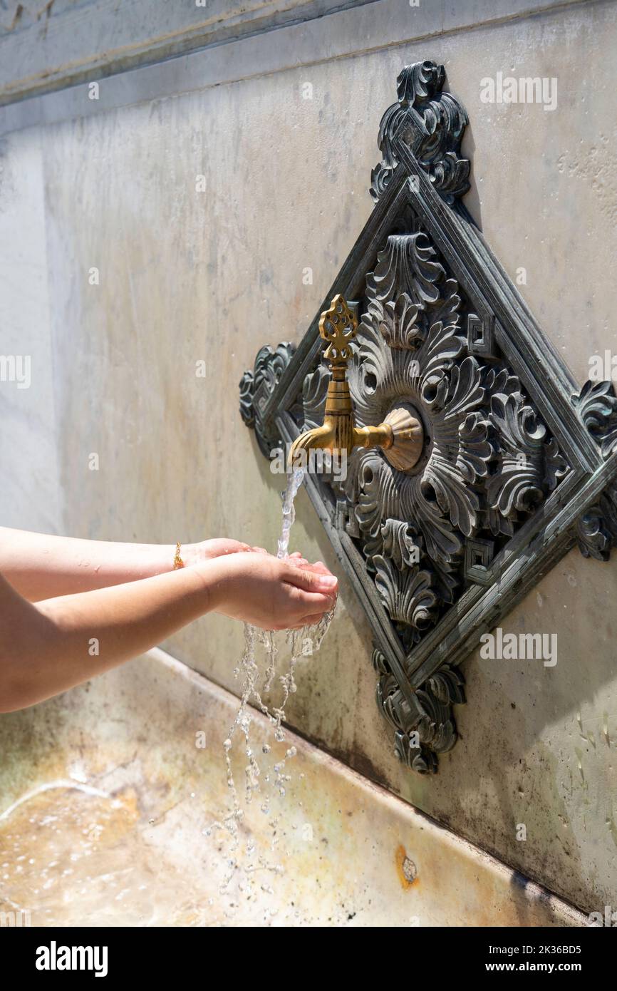 Human hand washing and cleaning with water outside from a old ottoman ...
