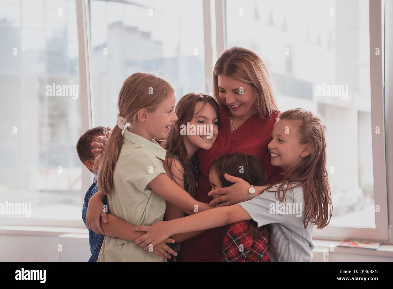 A child hugging a teacher in a modern kindergarten Stock Photo - Alamy