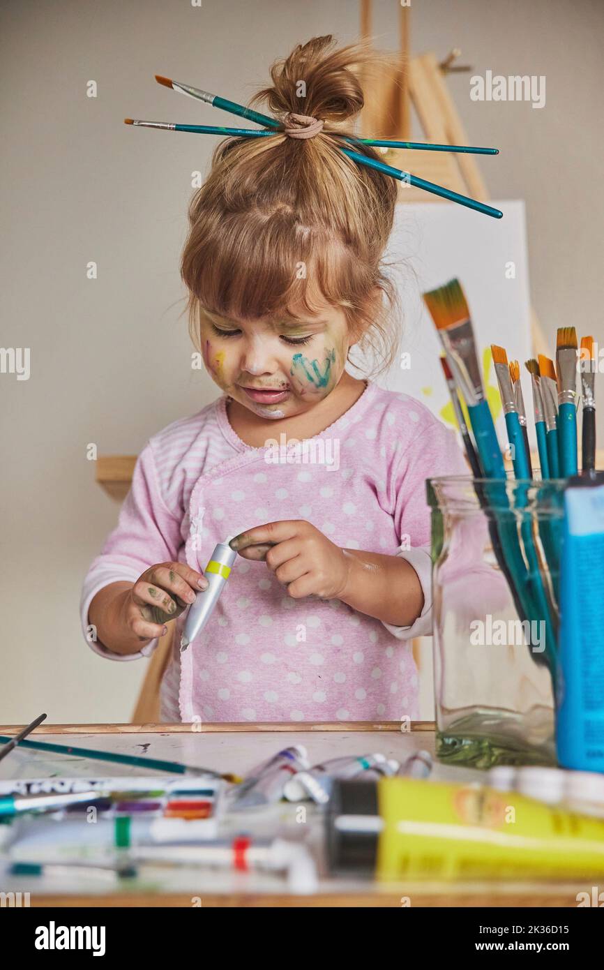 Charming dirty child draws at home with acrylics Stock Photo - Alamy