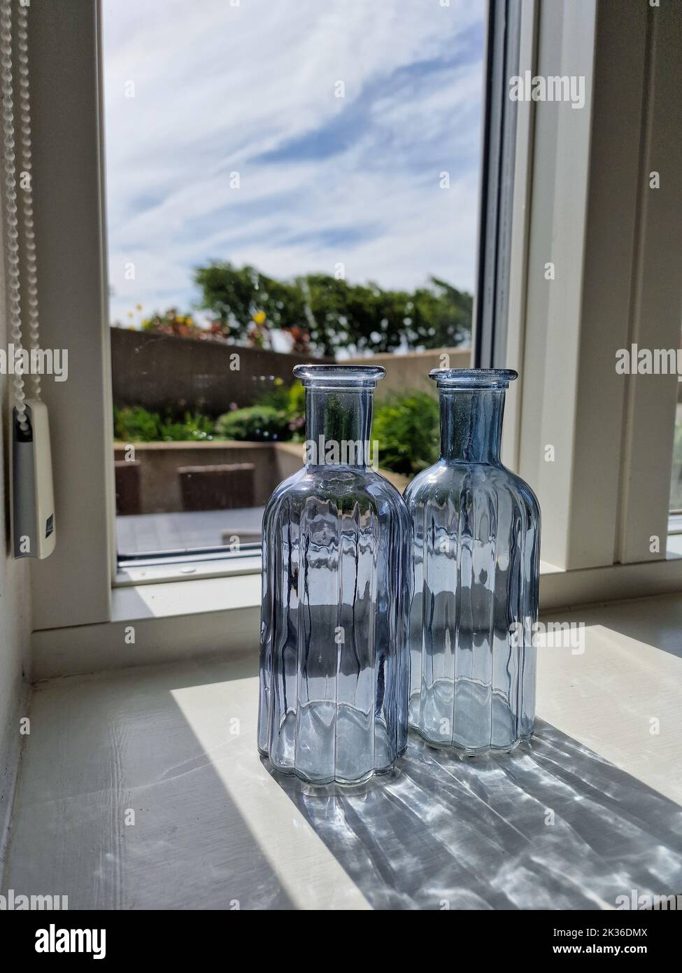 A two empty glass vase on a window sill,vertical shot Stock Photo - Alamy