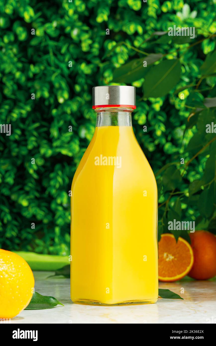 bottle of fresh orange juice with fresh fruits over a green background ...