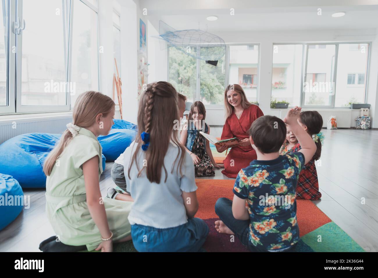 Reading time in an elementary school or kindergarten, a teacher reads a ...