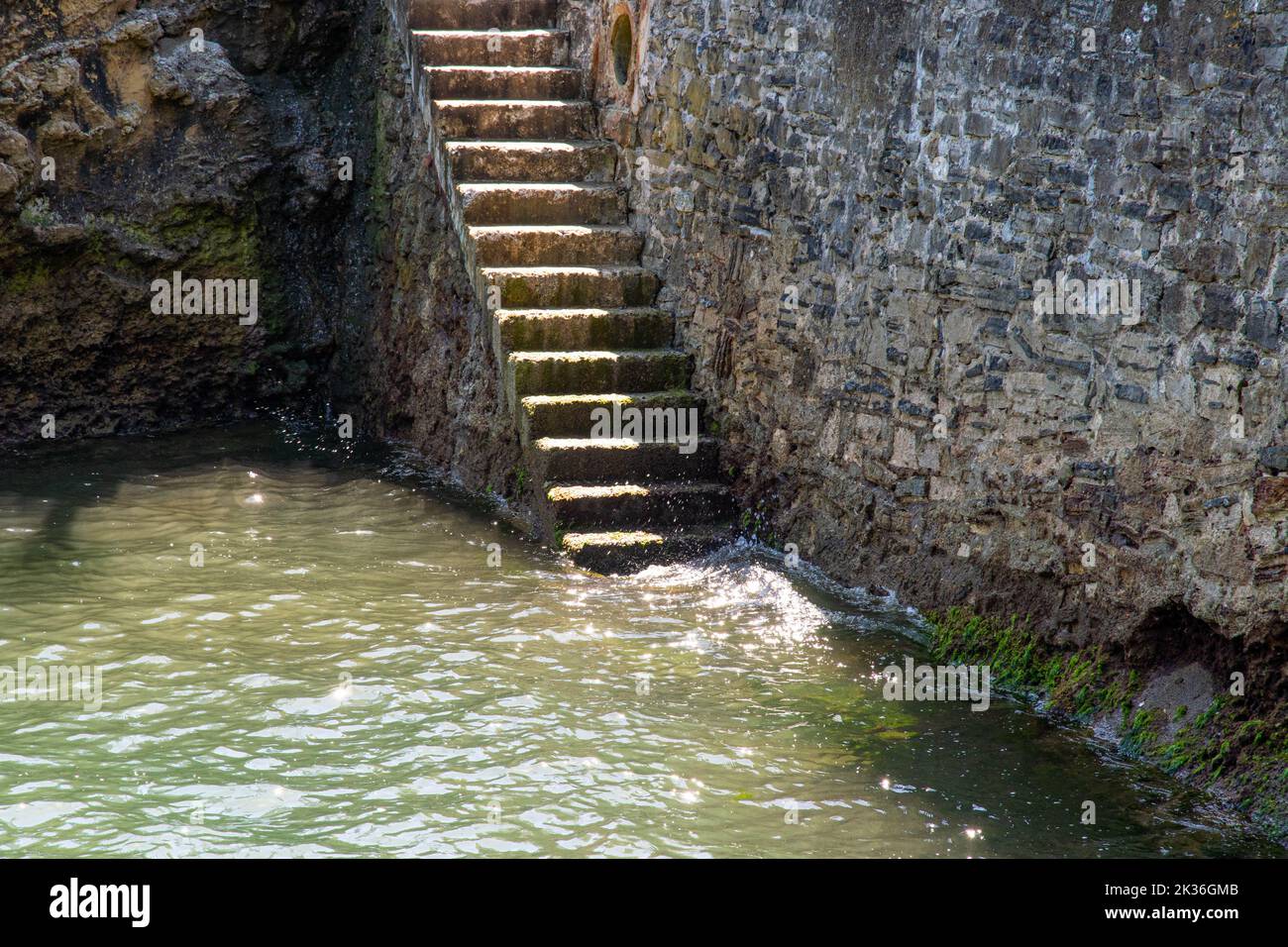 Stone steps on the quay wall at the harbour directly into the water ...
