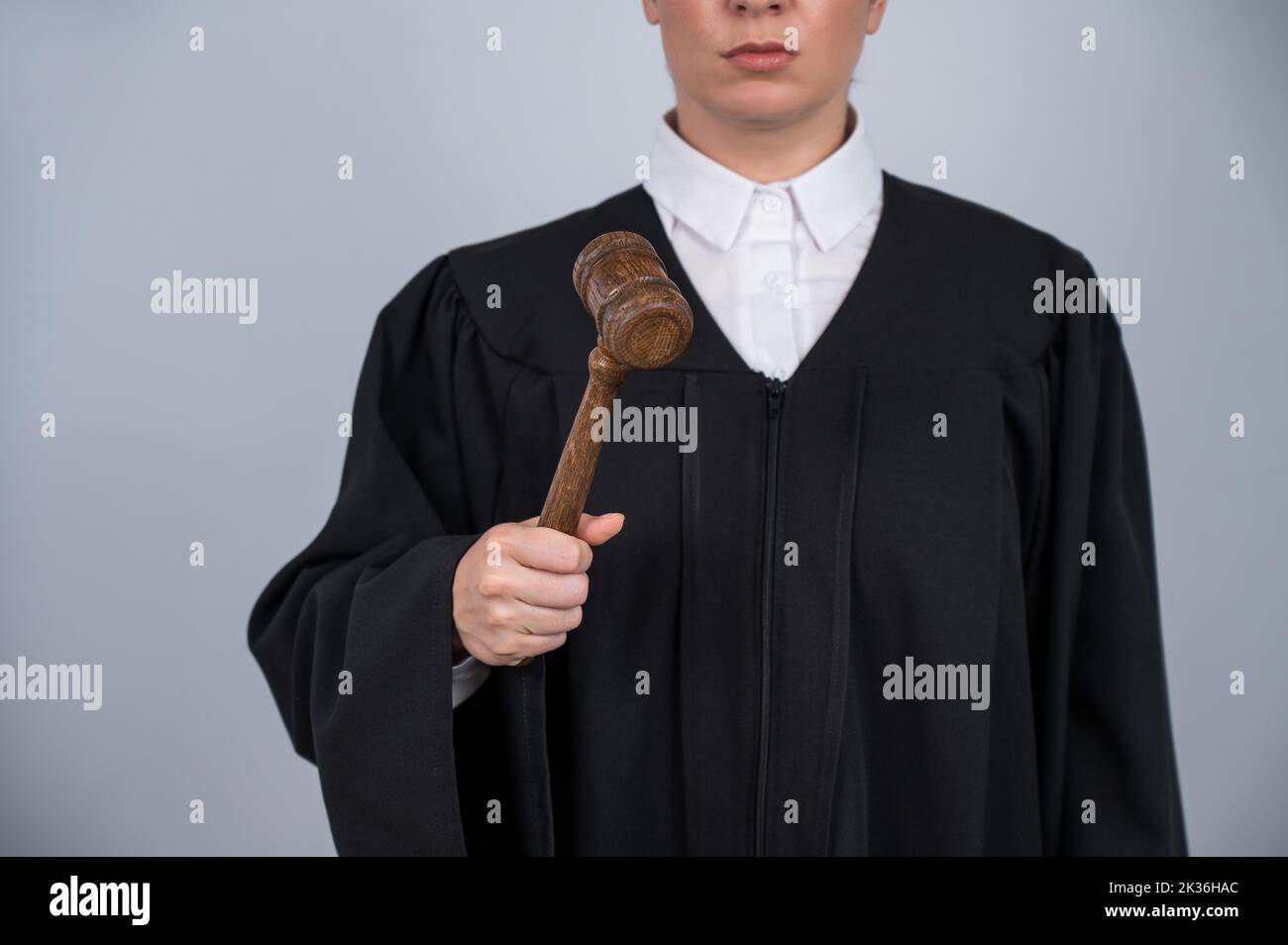 Faceless female judge in a robe holding a court gavel Stock Photo - Alamy