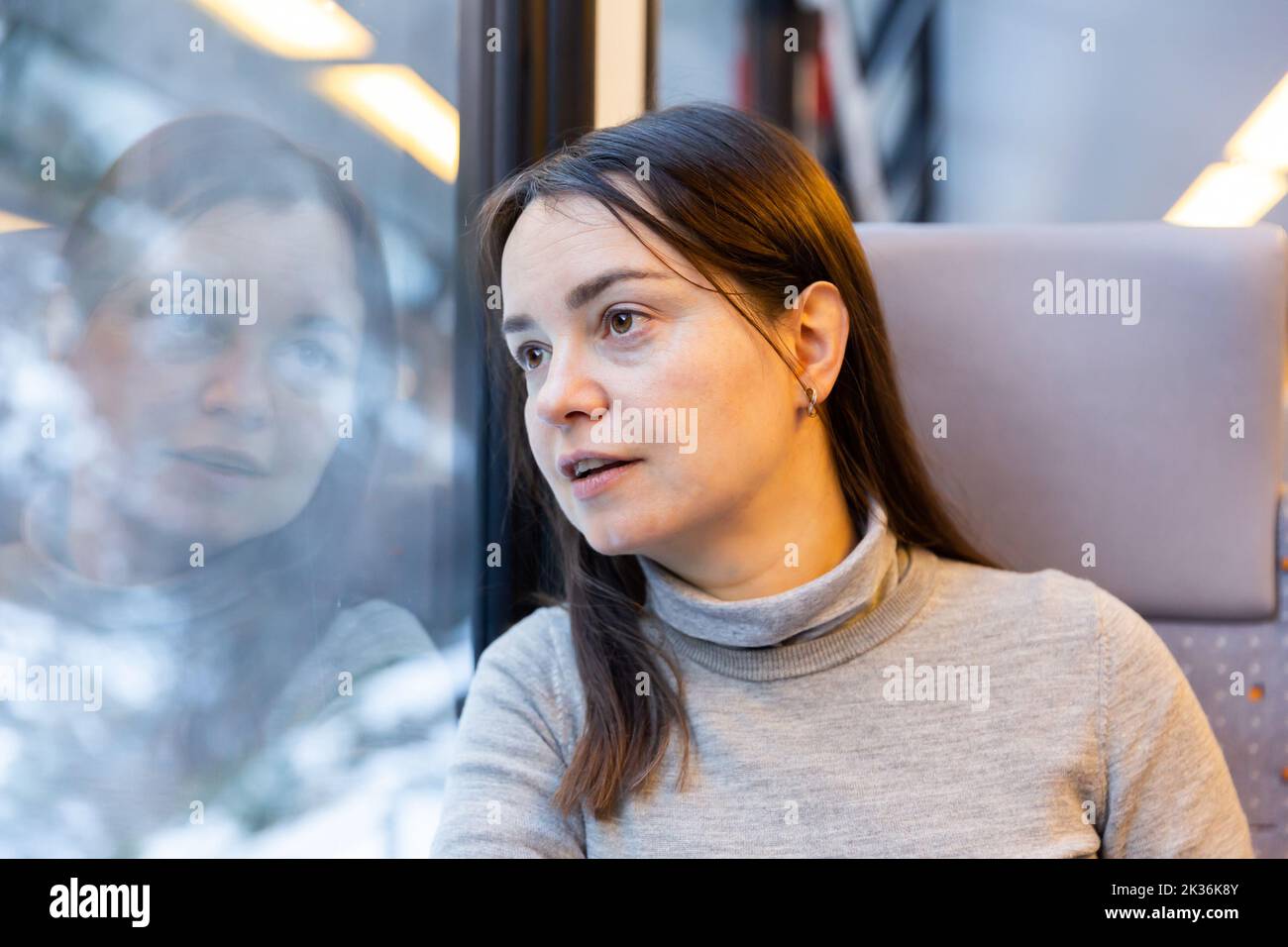 Woman looking through train window while journeying Stock Photo - Alamy