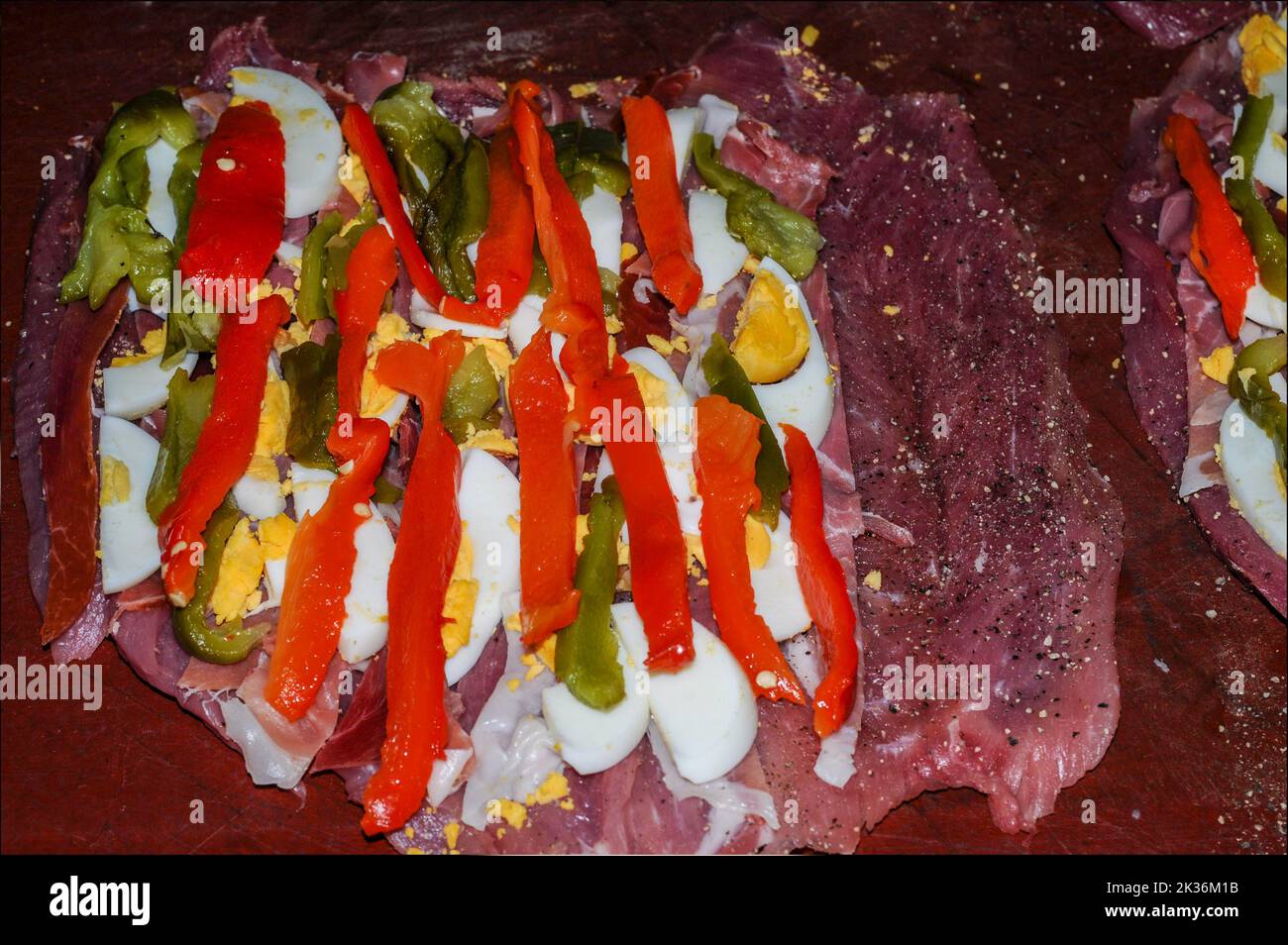Cooking an open loin, with ham, hard-boiled egg and green and red ...