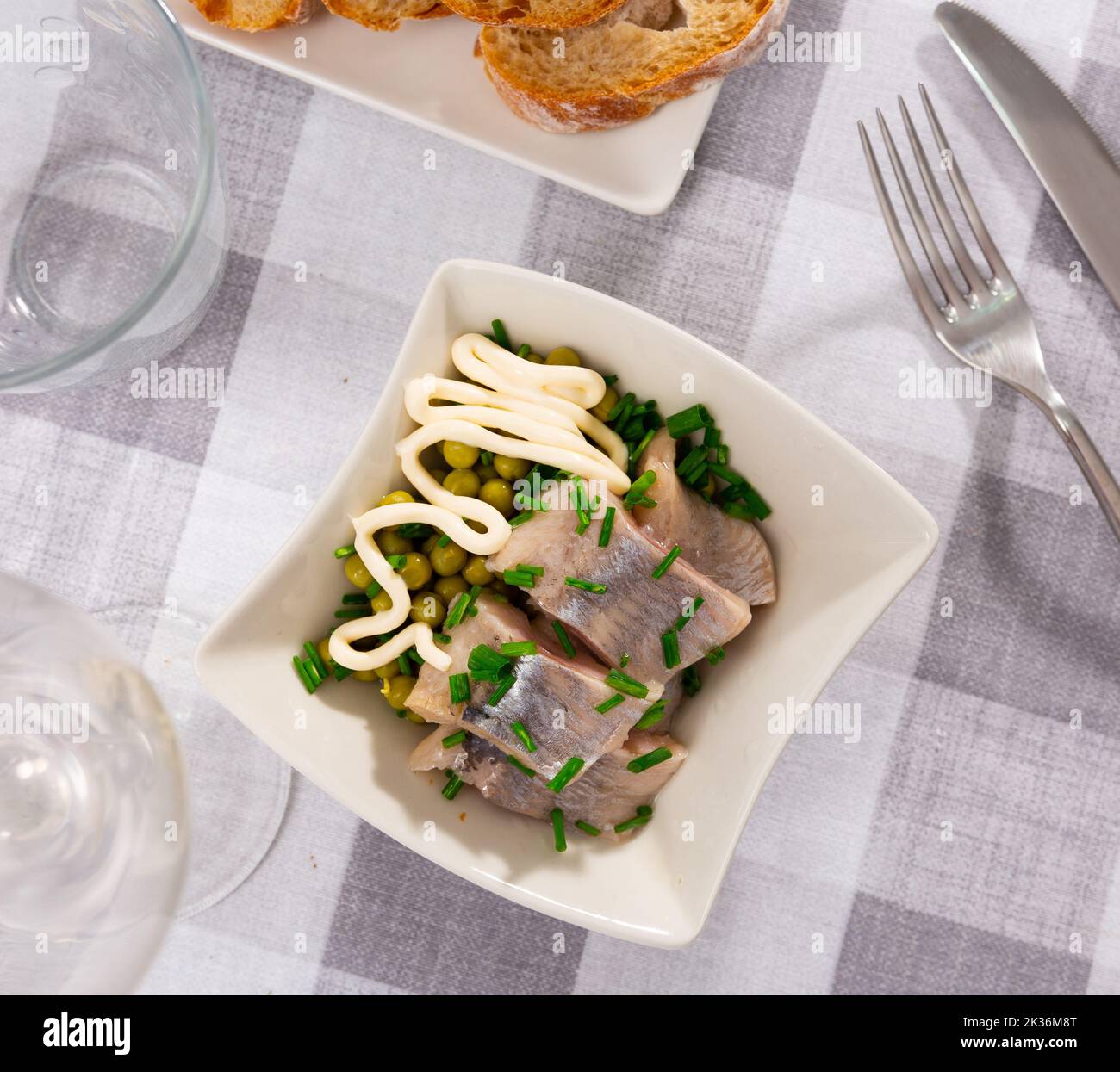 Pieces of herring served with green peas and onions. Appetizer fish on ...