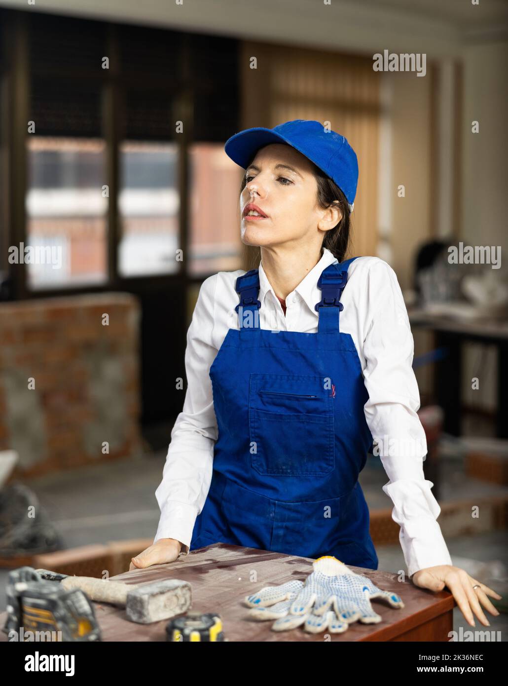 Woman construction worker posing inside house under renovation Stock ...