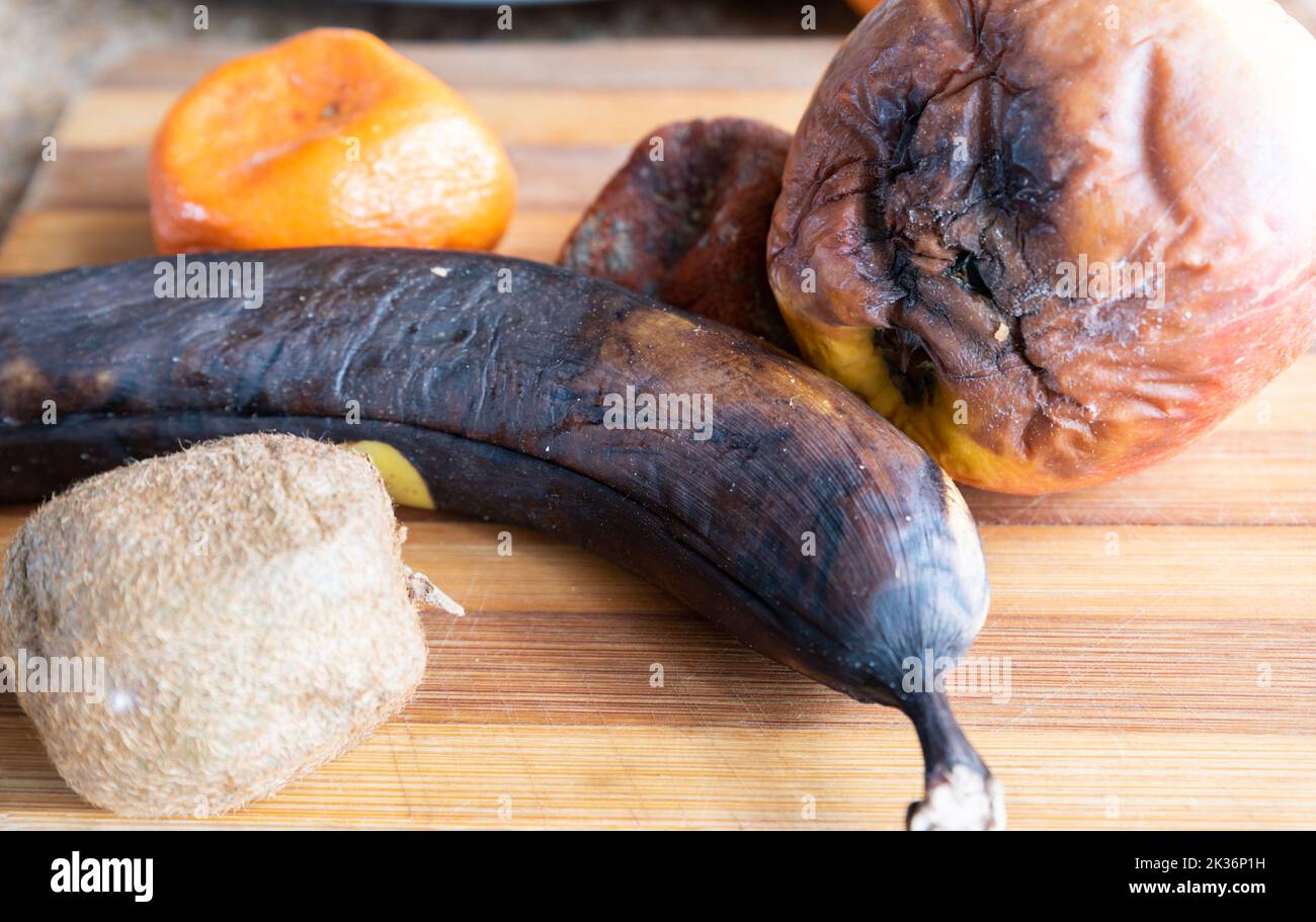 Rotten fruit on a bamboo board in close-up. Old citrus fruit. Spoiled ...