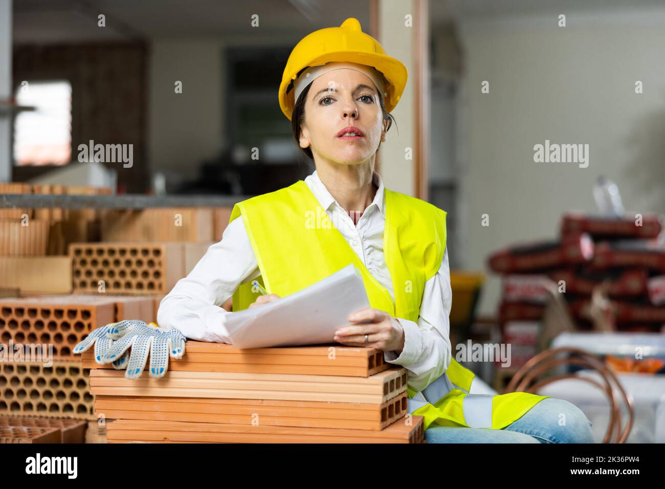 Female supervisor taking notes while inspecting construction site ...