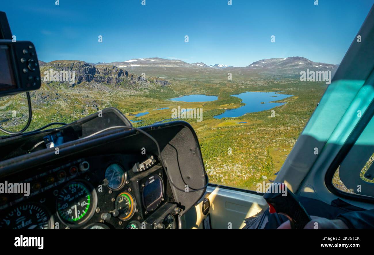 View from cockpit of small helicopter on lakes and mountains in vast ...