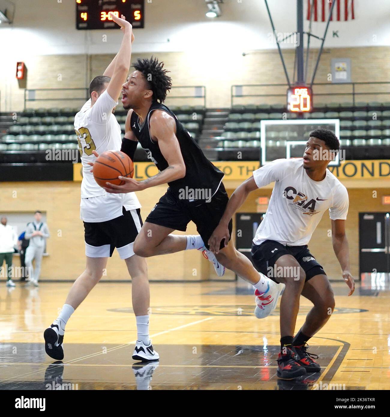 A basketball player dribbling the ball into the hoop Stock Photo - Alamy