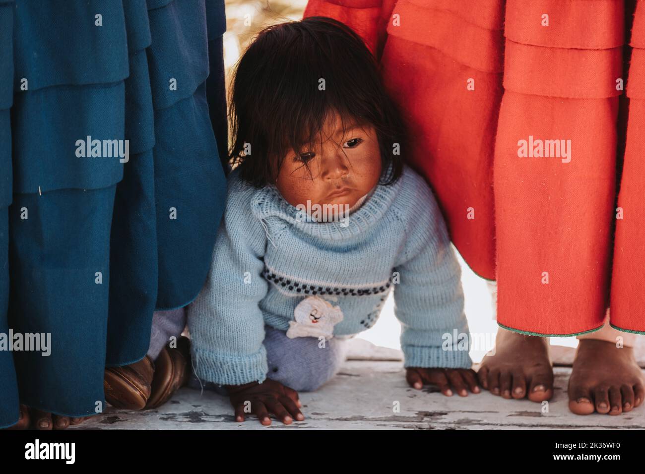 A child sitting on floor of Uros Island, Peru. Uru or Uros - indigenous ...
