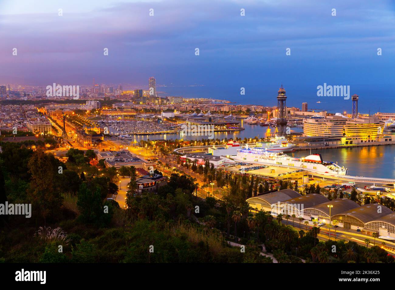 Aerial view of Barcelona on Mediterranean coast with seaport in evening ...