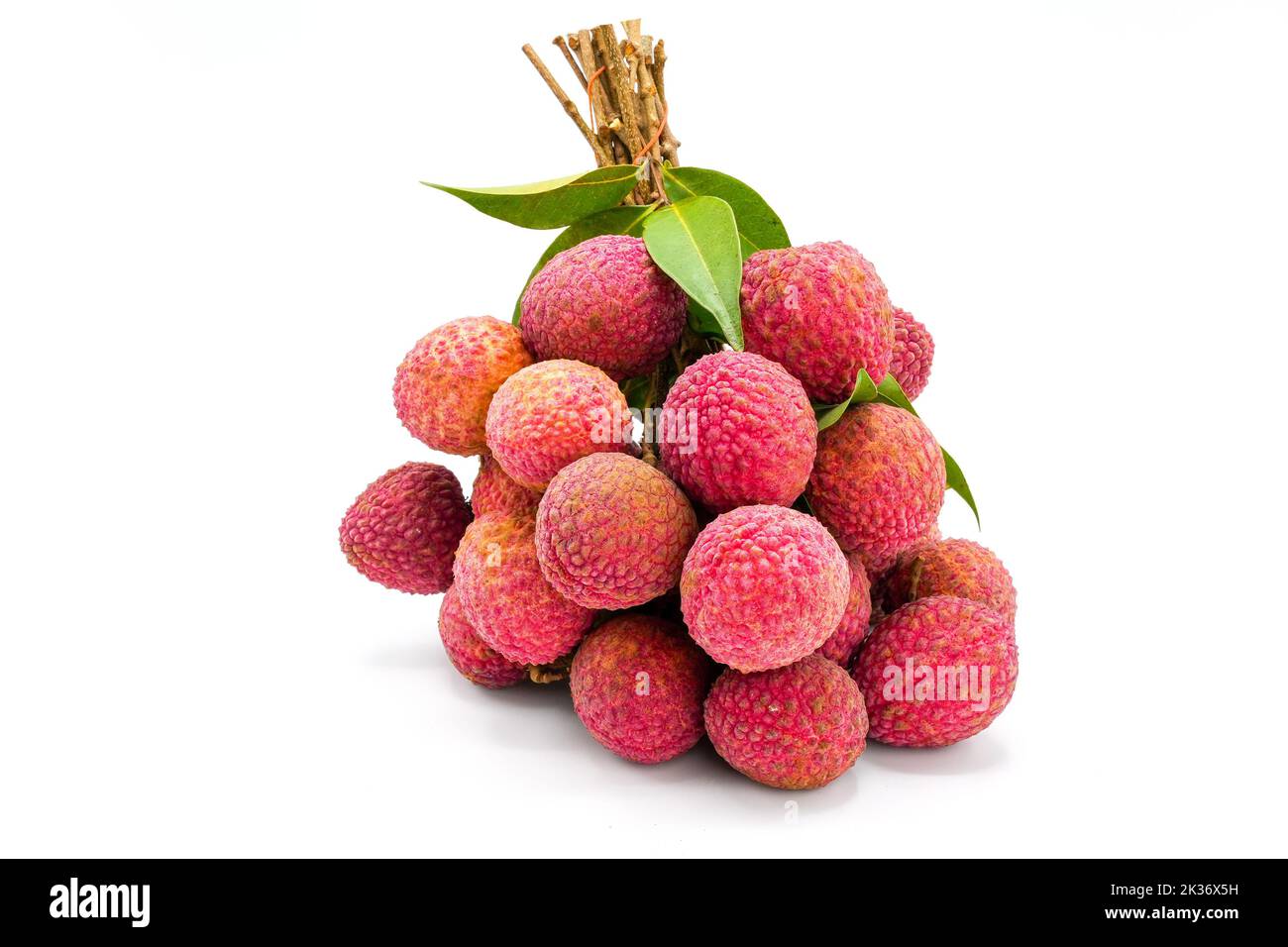 A bunch of pink Lychee fruits with green leaves isolated on white ...