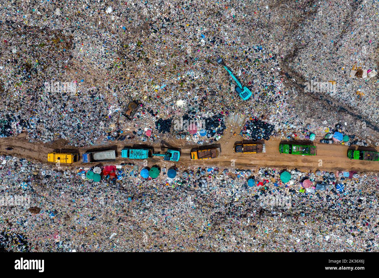 Garbage trucks unload garbage over the landfill. Pollution concept ...