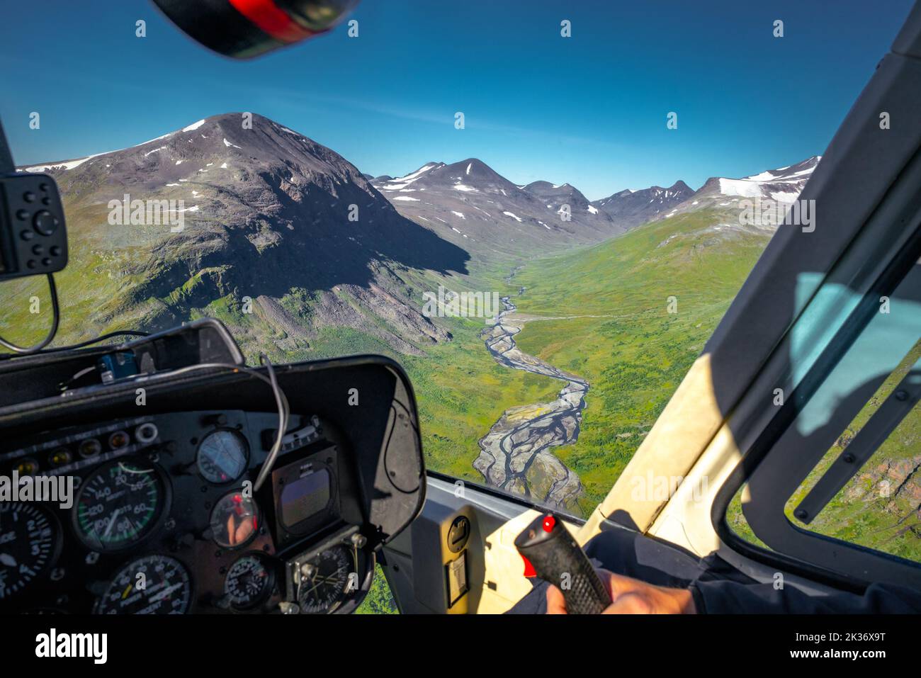 View from cockpit of small helicopter on wild river and mountains in ...