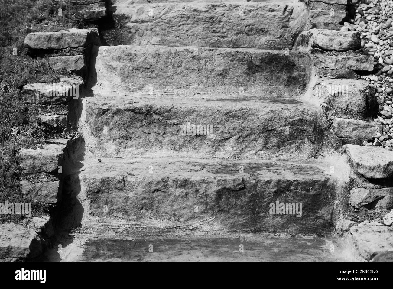 Ancient uneven stone stairs with weathered steps in a black and white ...
