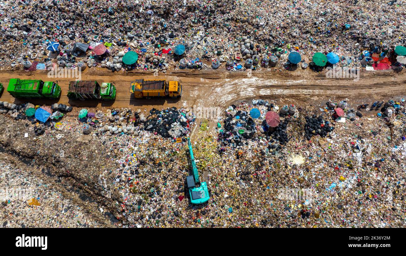 Garbage trucks unload garbage over the landfill. Pollution concept ...