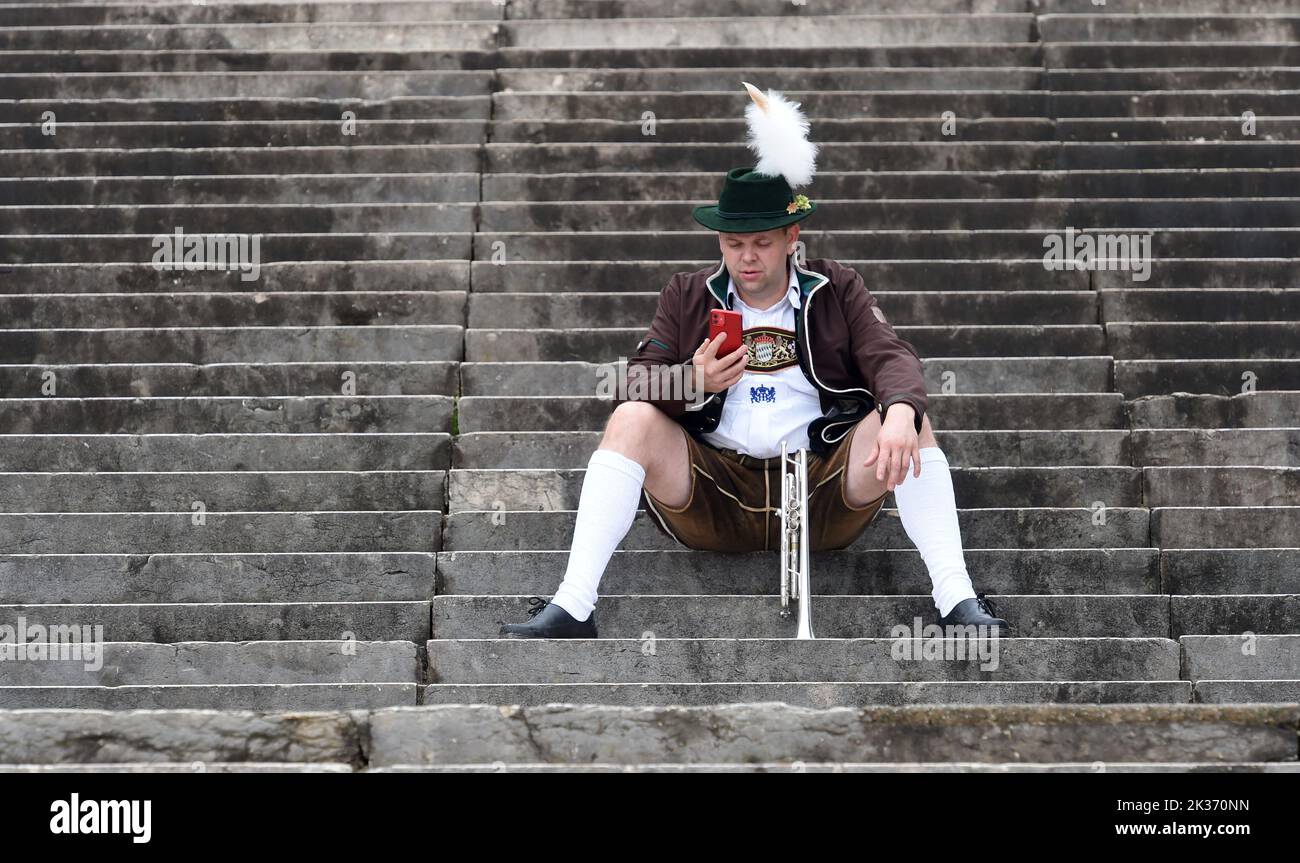 25 September 2022, Bavaria, Munich: Musician Andreas sits on the steps ...