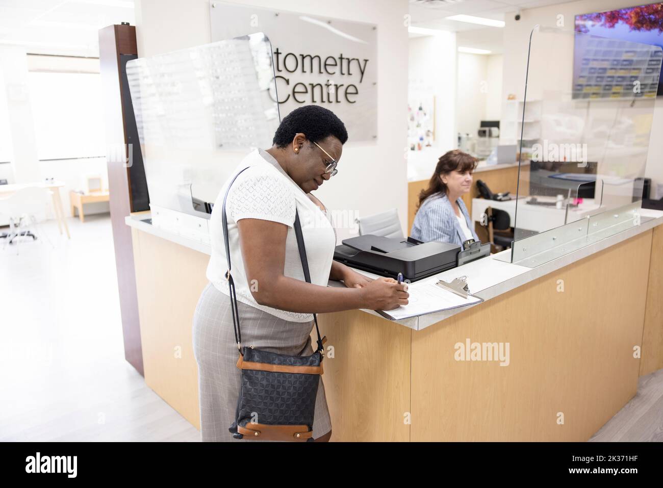 Woman filling form reception desk hi-res stock photography and images ...