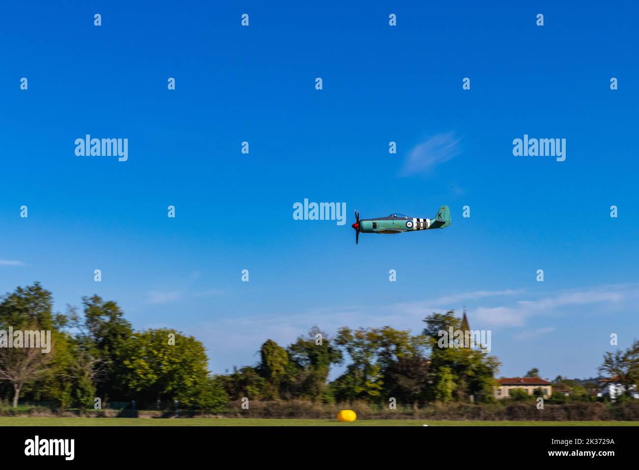 An old helicopter from the Second world war flying over the field with ...