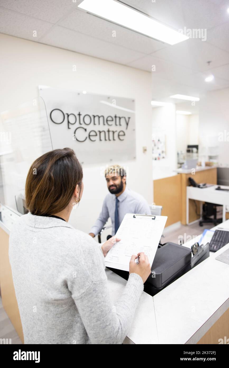 Woman filling form reception desk hi-res stock photography and images ...