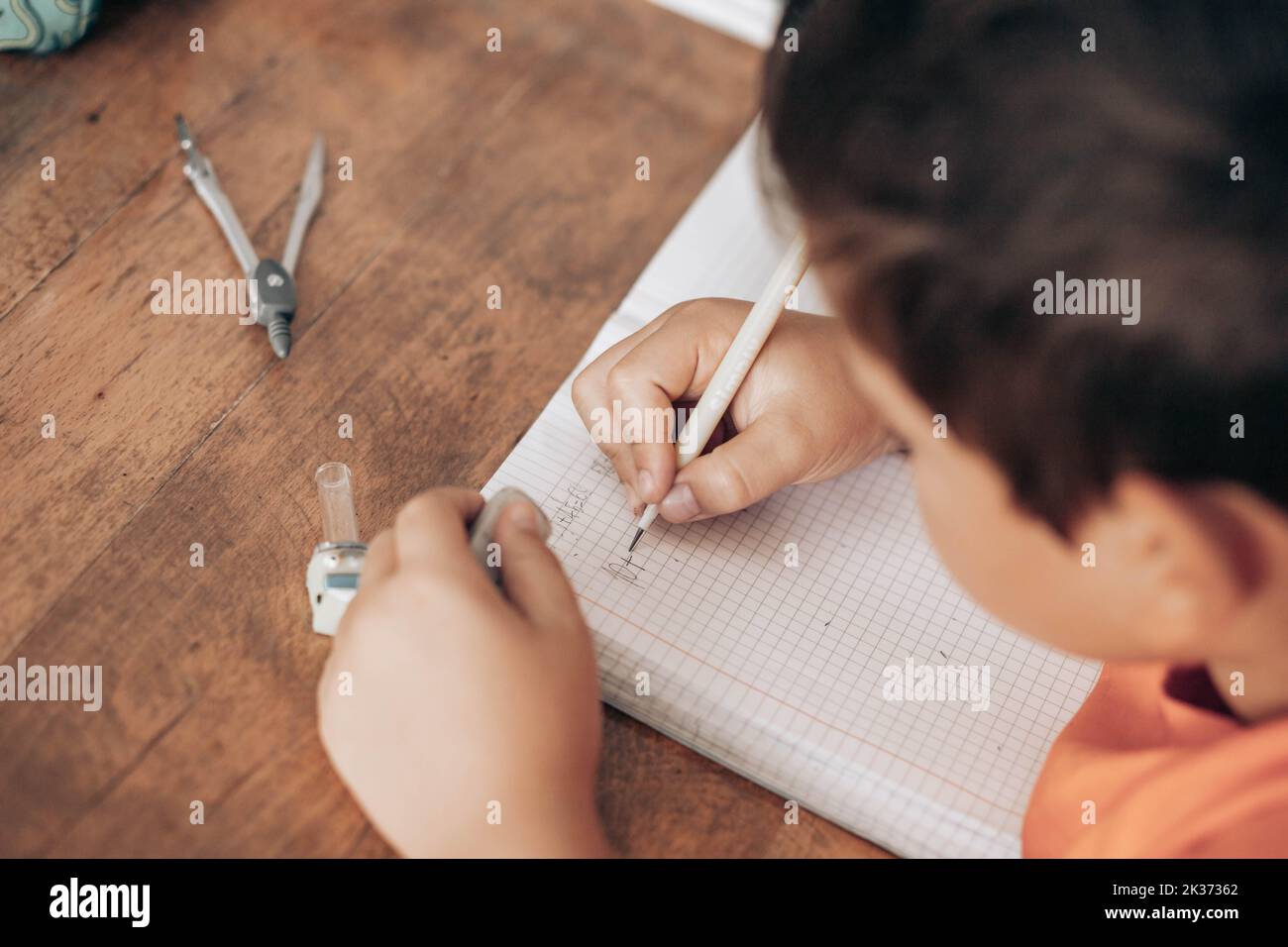 Little school boy writing in his notebook. Top view Stock Photo - Alamy