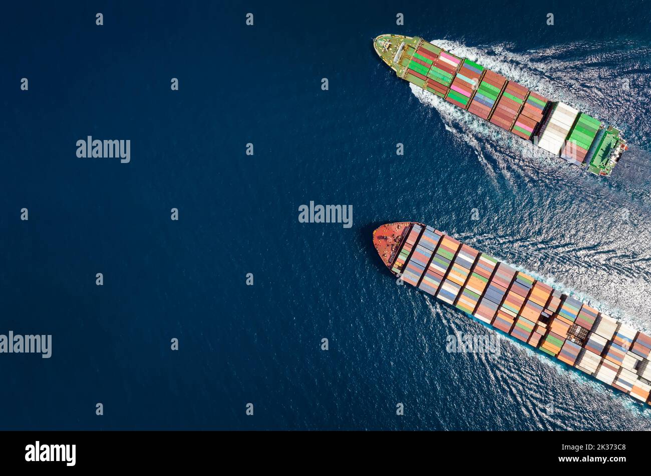 High aerial top down view of two container cargo ships traveling over ...