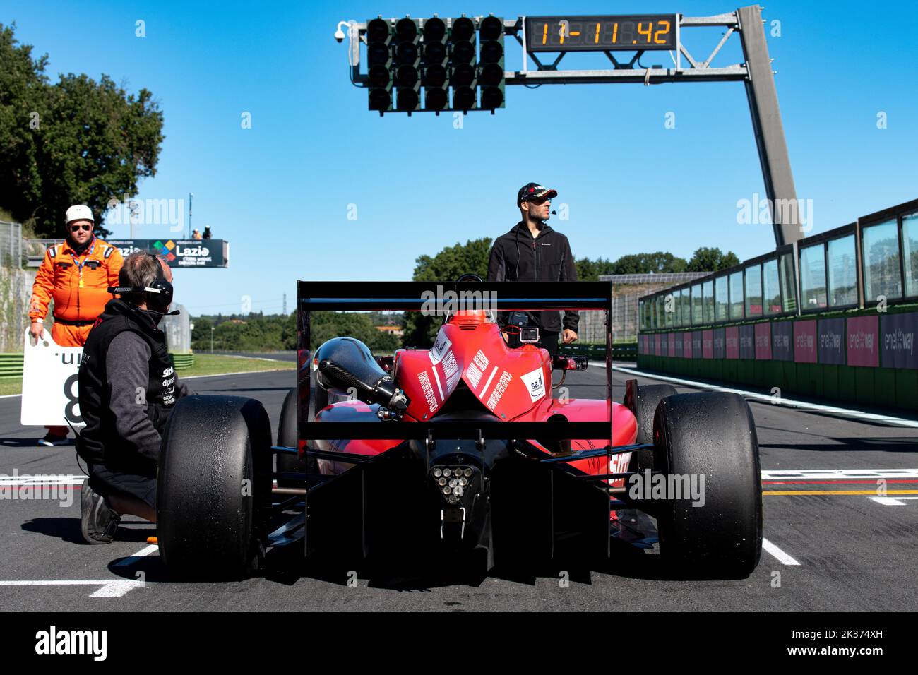 Rear view of racing formula car standing in racetrack starting grid ...