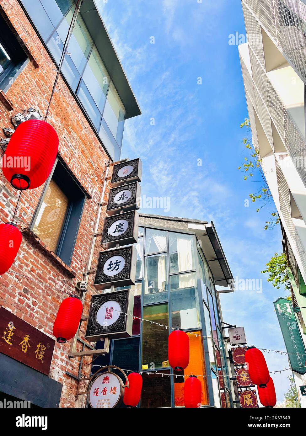 A vertical low angle of festive red lanterns, characteristic buildings ...