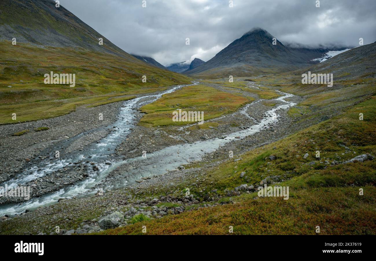Wild river flowing through harsh, remote arctic valley on a cloudy ...