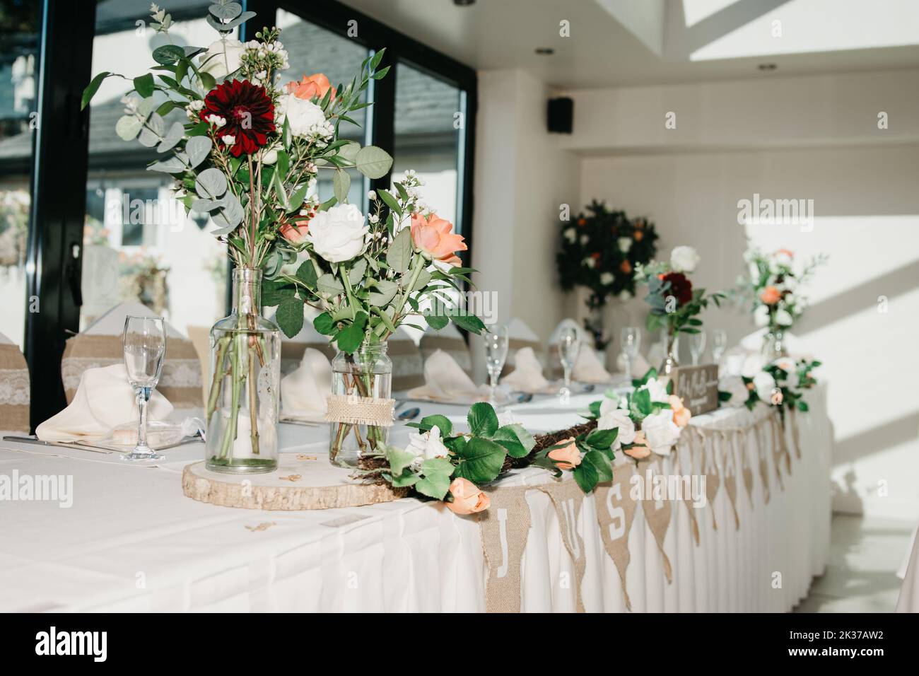 Rustic Wedding Reception Top Table seating with glasses, cutlery and ...