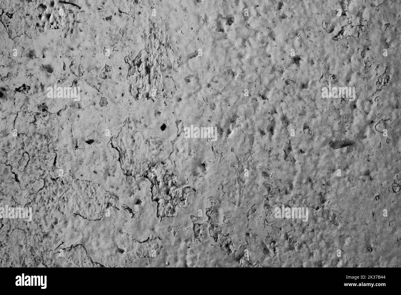 Painted concrete surface with pockmarks in a black and white monochrome ...