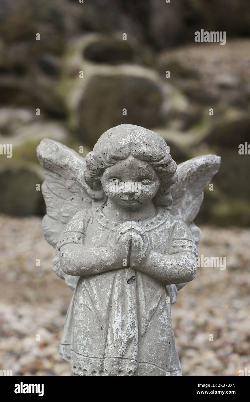 Cute stone angel statue praying with her hands Stock Photo - Alamy