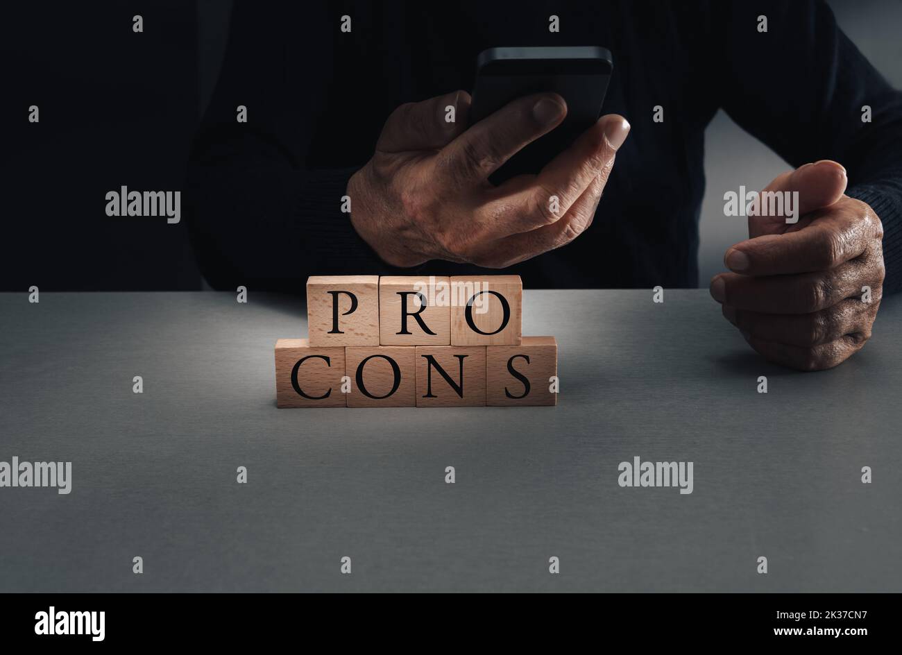 pro's and cons on wooden blocks with man looking at mobile phone blue ...